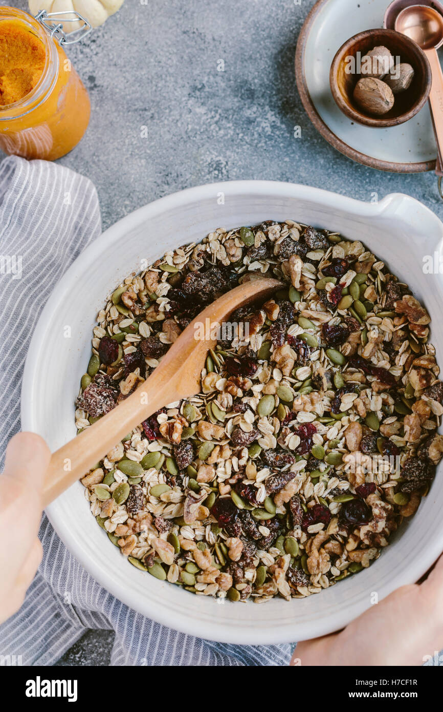 A woman is mixing nuts and other ingredients to make a batter for a ...