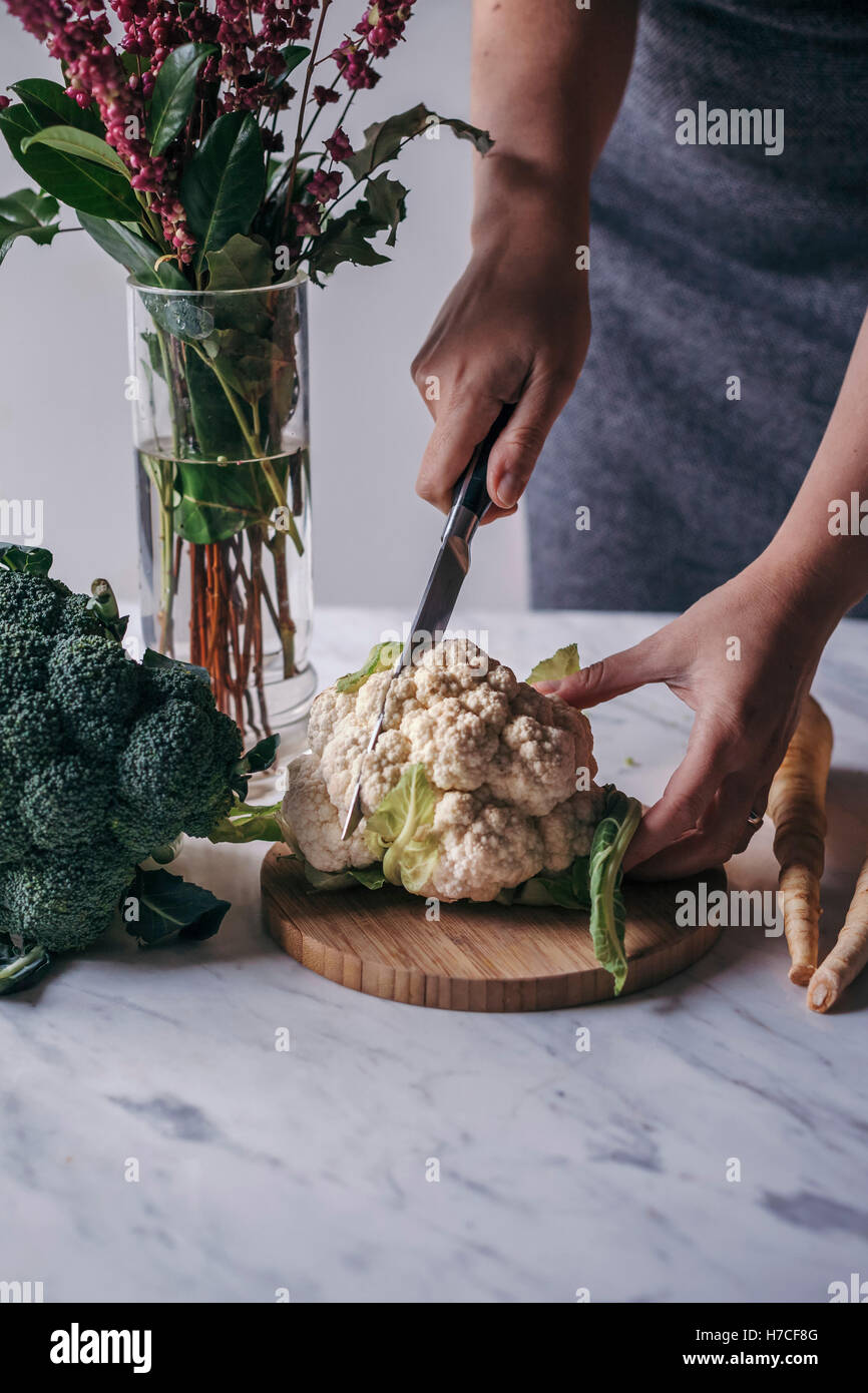 Woman cutting through cauliflower Stock Photo - Alamy