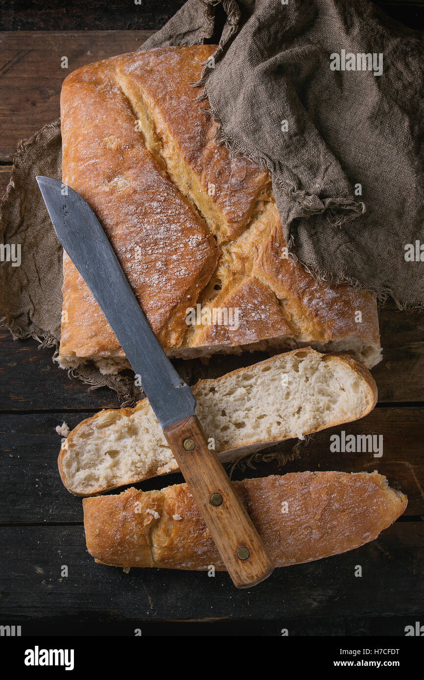 Fresh slice artisan bread under sackcloth with vintage knife over old ...