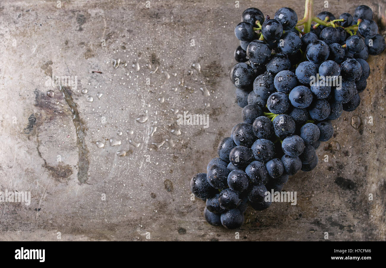 Bunch of ripe wet red grapes over old texture metal background. Top ...