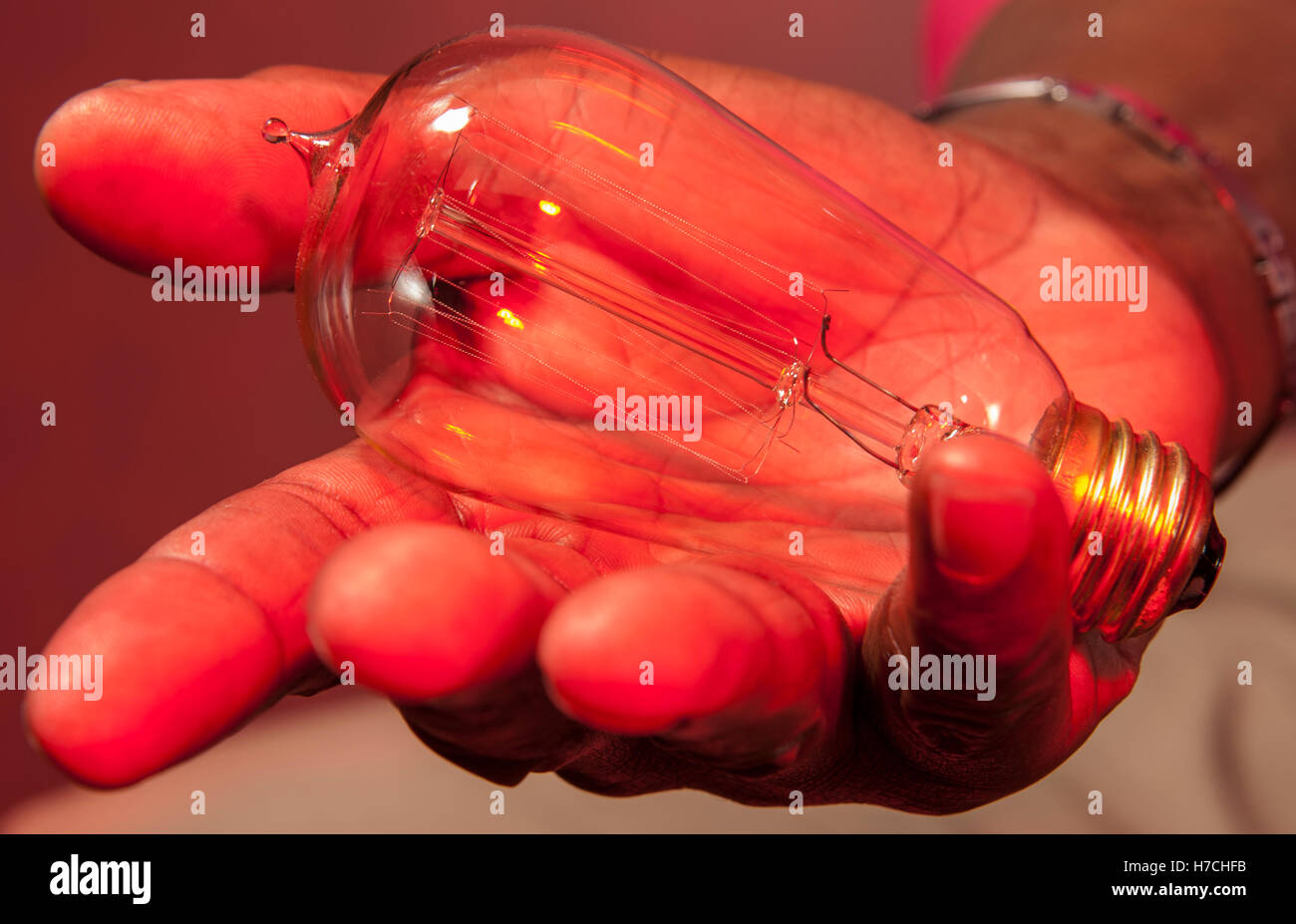 Lightbulb held in hand Stock Photo - Alamy
