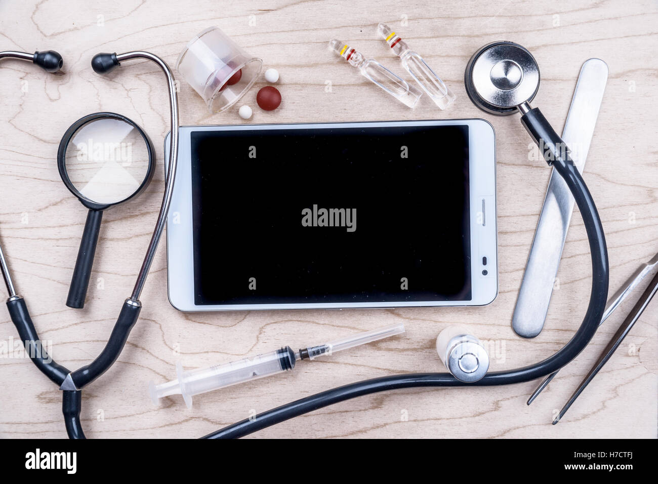 Tablet pc with medical objects on a desk Stock Photo - Alamy