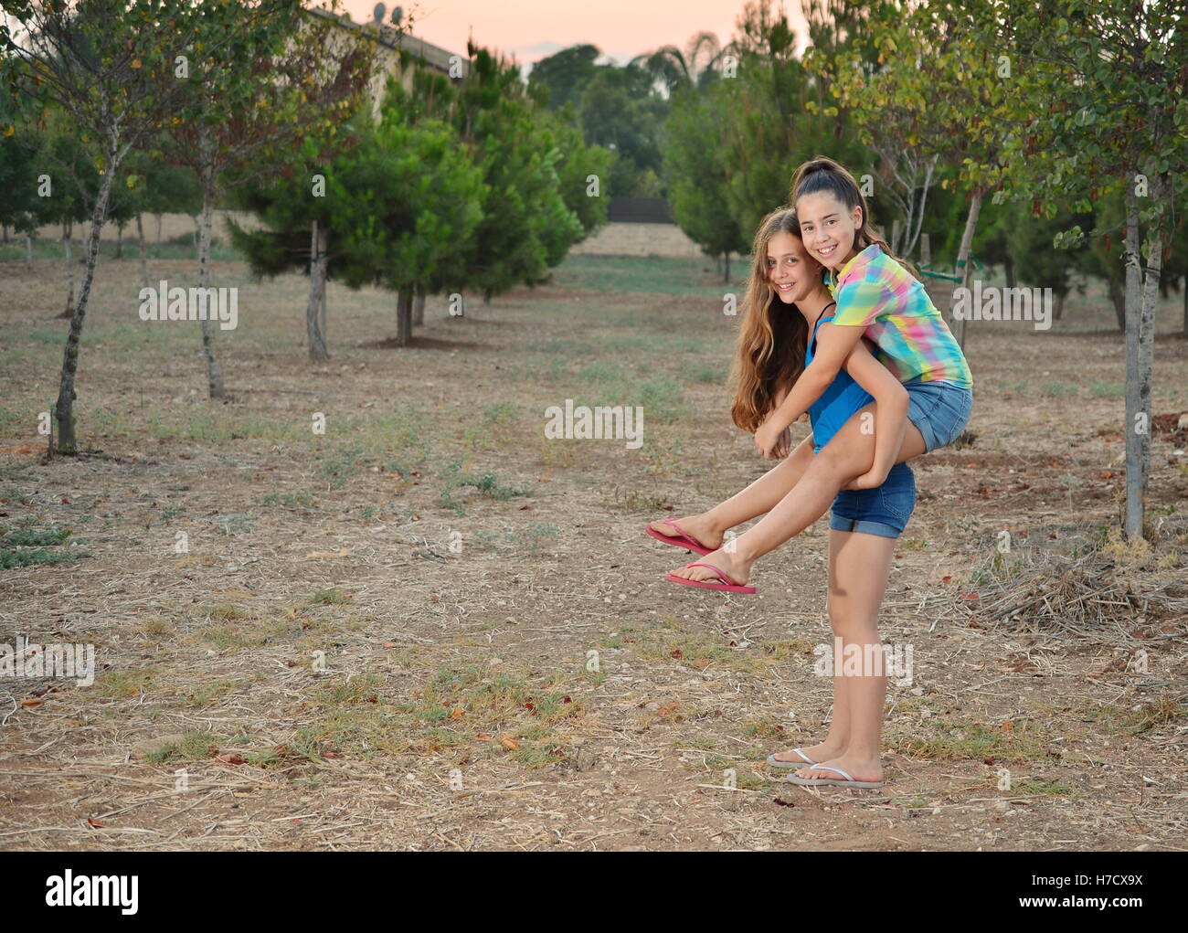 Best Friends Forever - two 12 year old teenage girls piggy-backing at ...