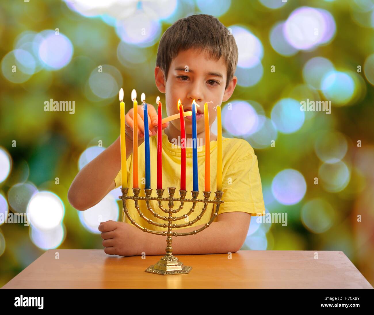 An Israeli 8 year old child lighting a Hanukkah Menorah Stock Photo - Alamy