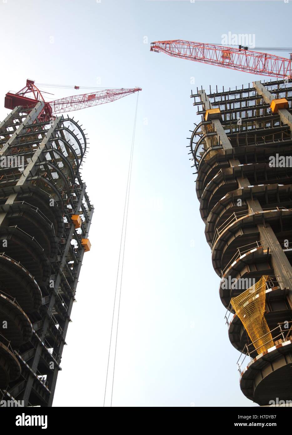 Two cranes works between two half finished high rise buildings Stock ...