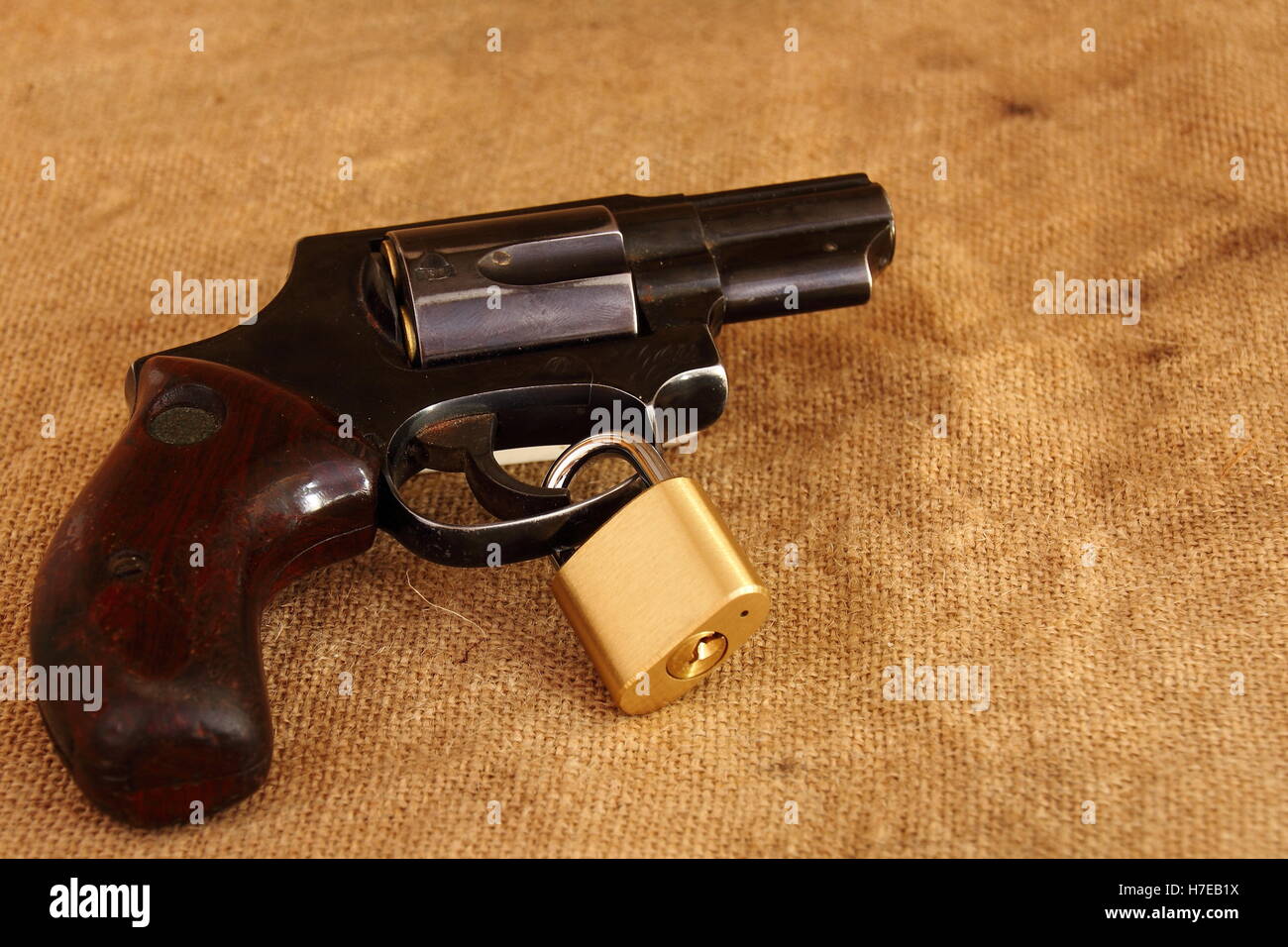 Handgun with a padlock around the trigger isolated on a clear ...