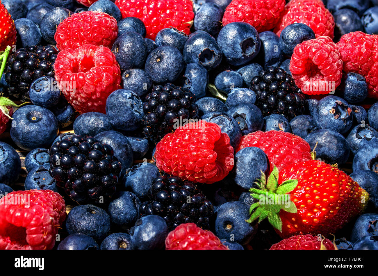 Raspberry, blackberry and blueberry on the old wooden board,background ...
