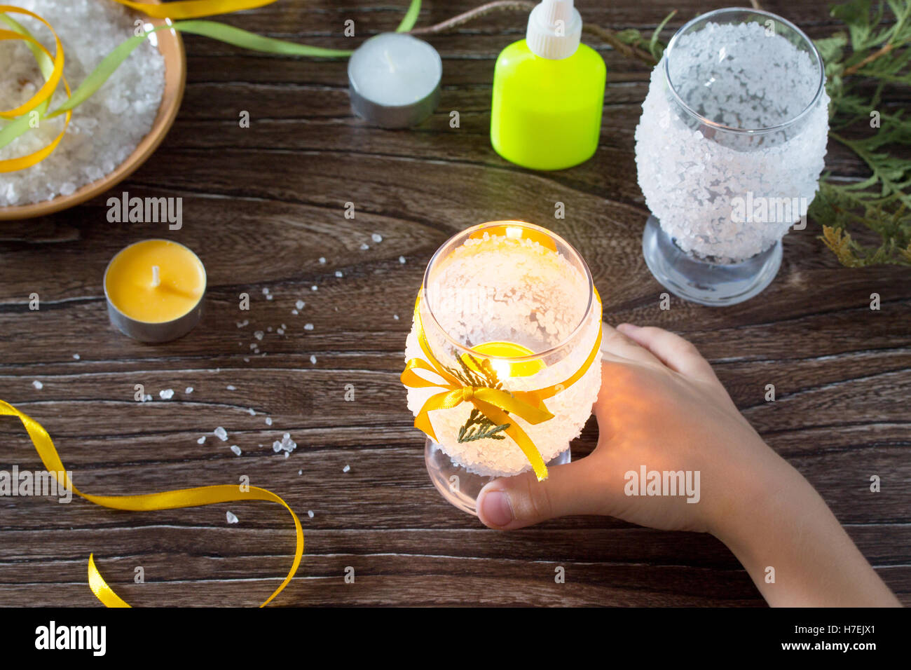 Children create a candlestick Christmas gift, candle in a glass ...