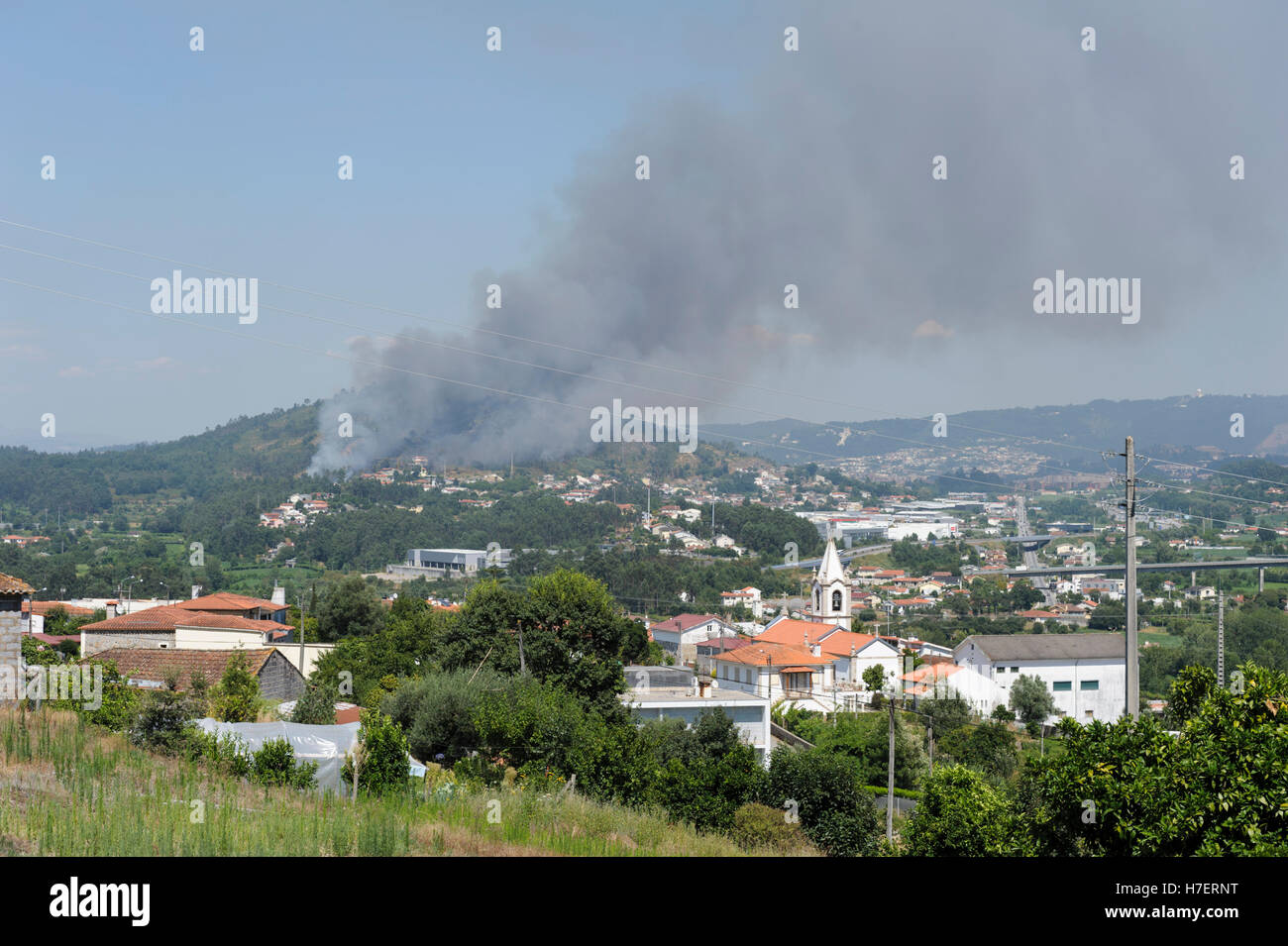 Plume of smoke from a forest and brush fire on hillside near Braga in ...