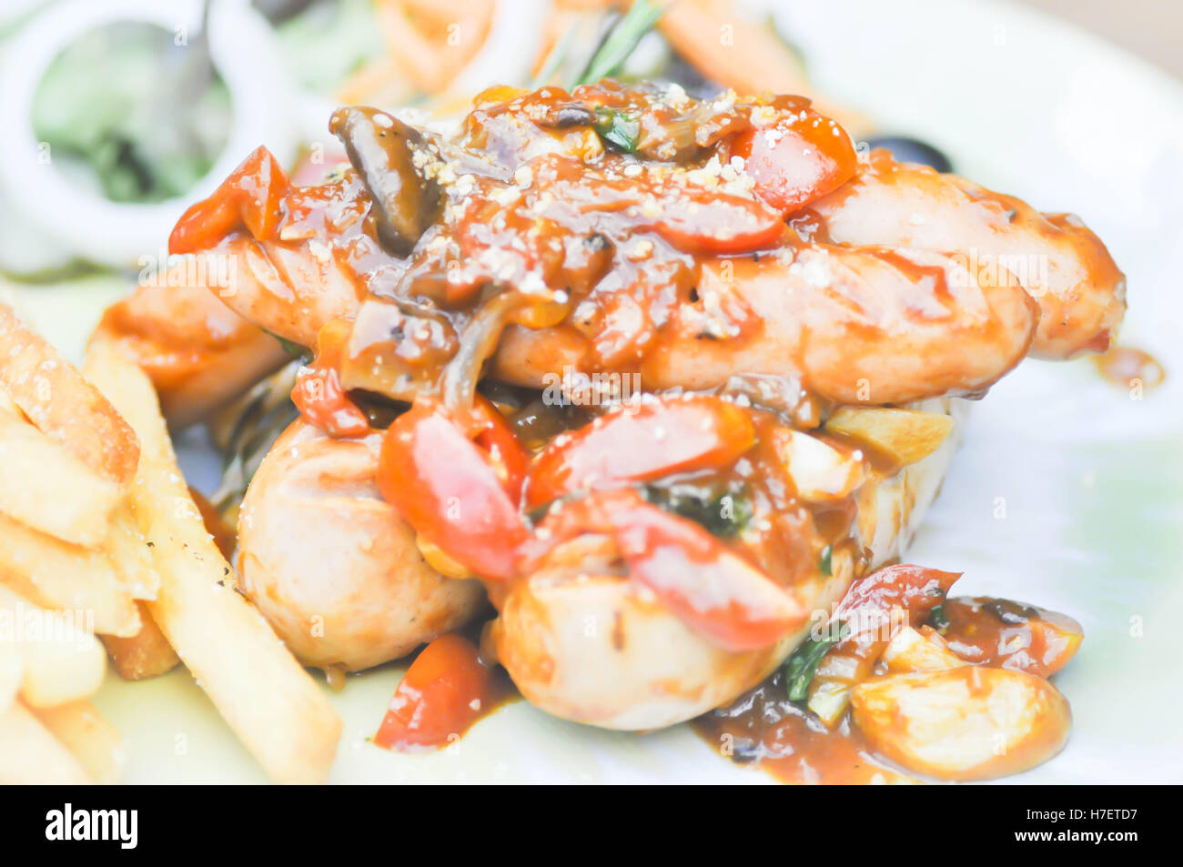 mixed sausage,sausage with gravy sauce topping dish Stock Photo - Alamy