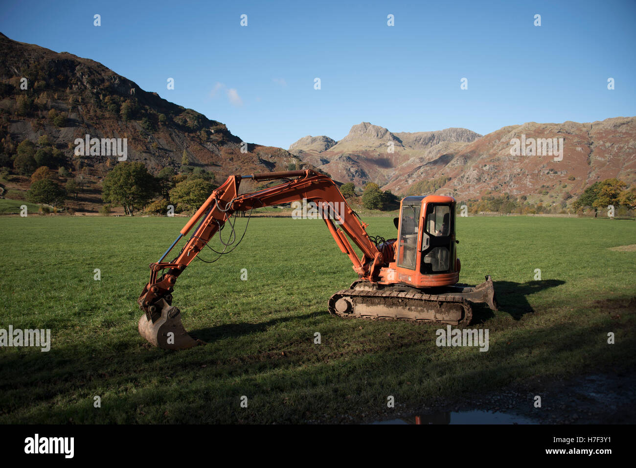 Orange mini digger in the Langdale Valley, Lake District, Cumbria, UK ...