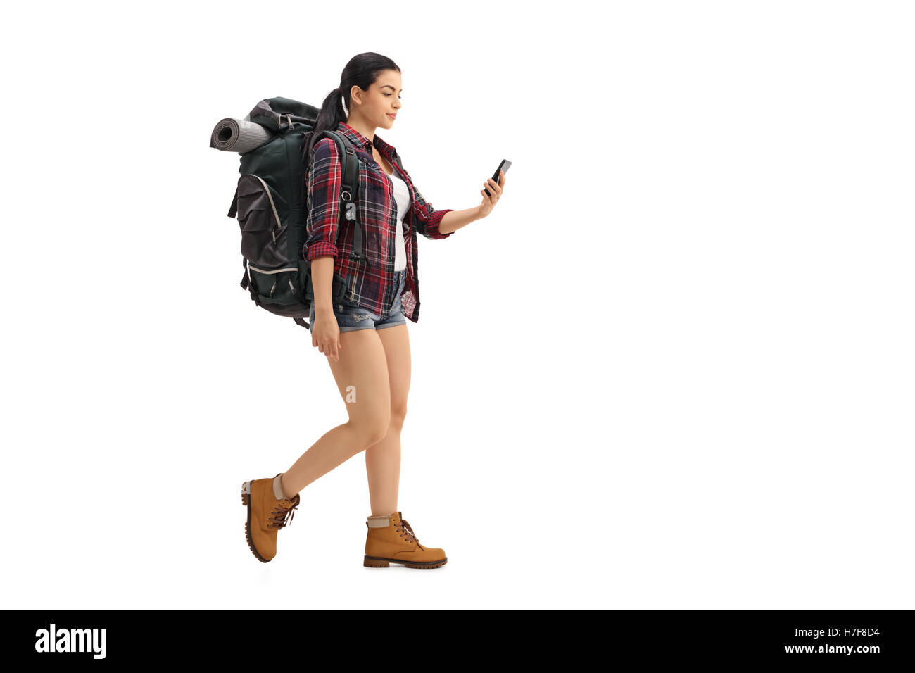 Full length profile shot of a female hiker walking and looking at a ...