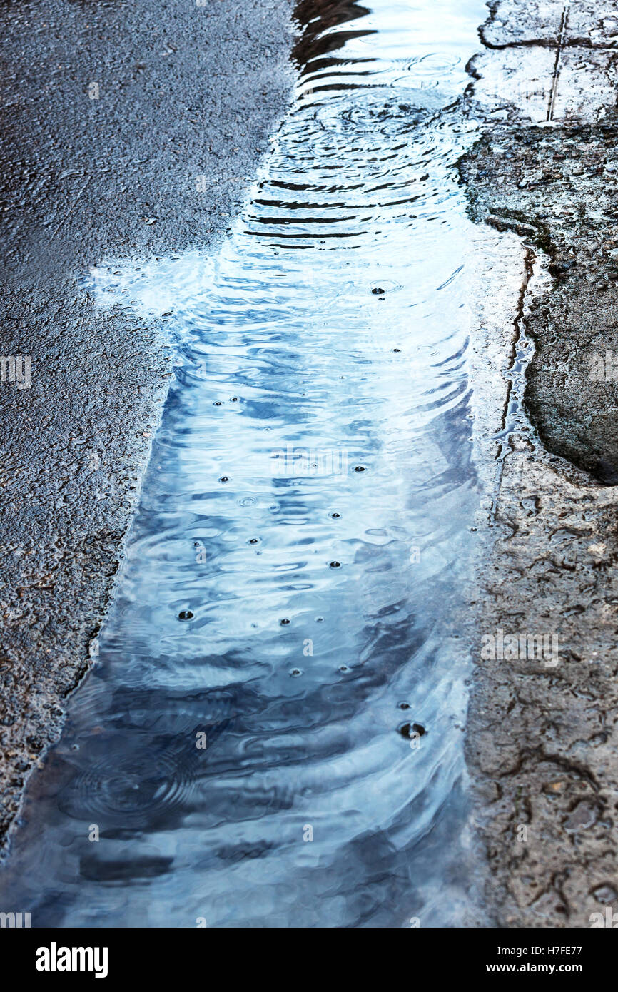 rain stream on the pavement in the city Stock Photo - Alamy