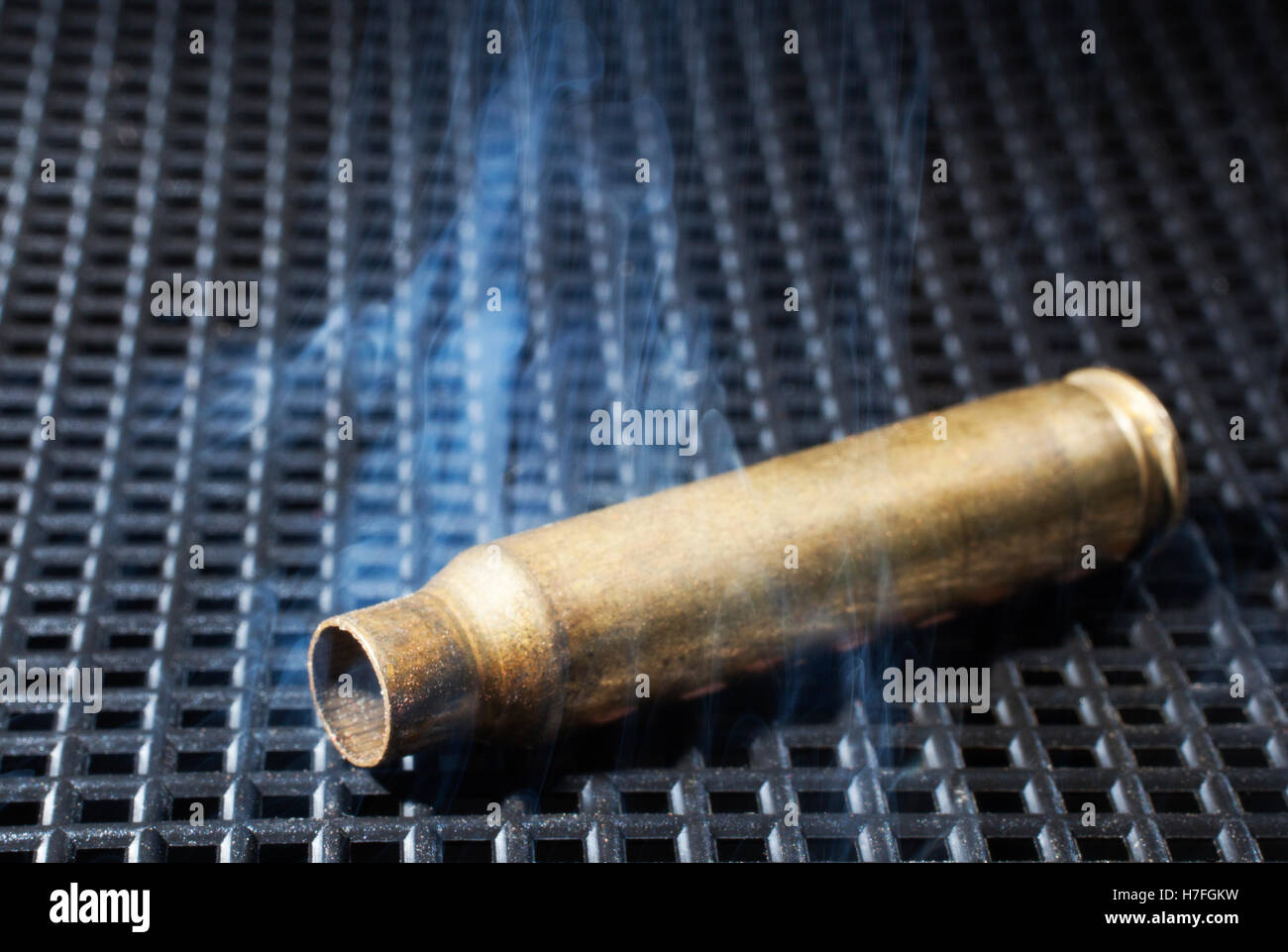 Rifle casing that is empty and has smoke all around Stock Photo - Alamy