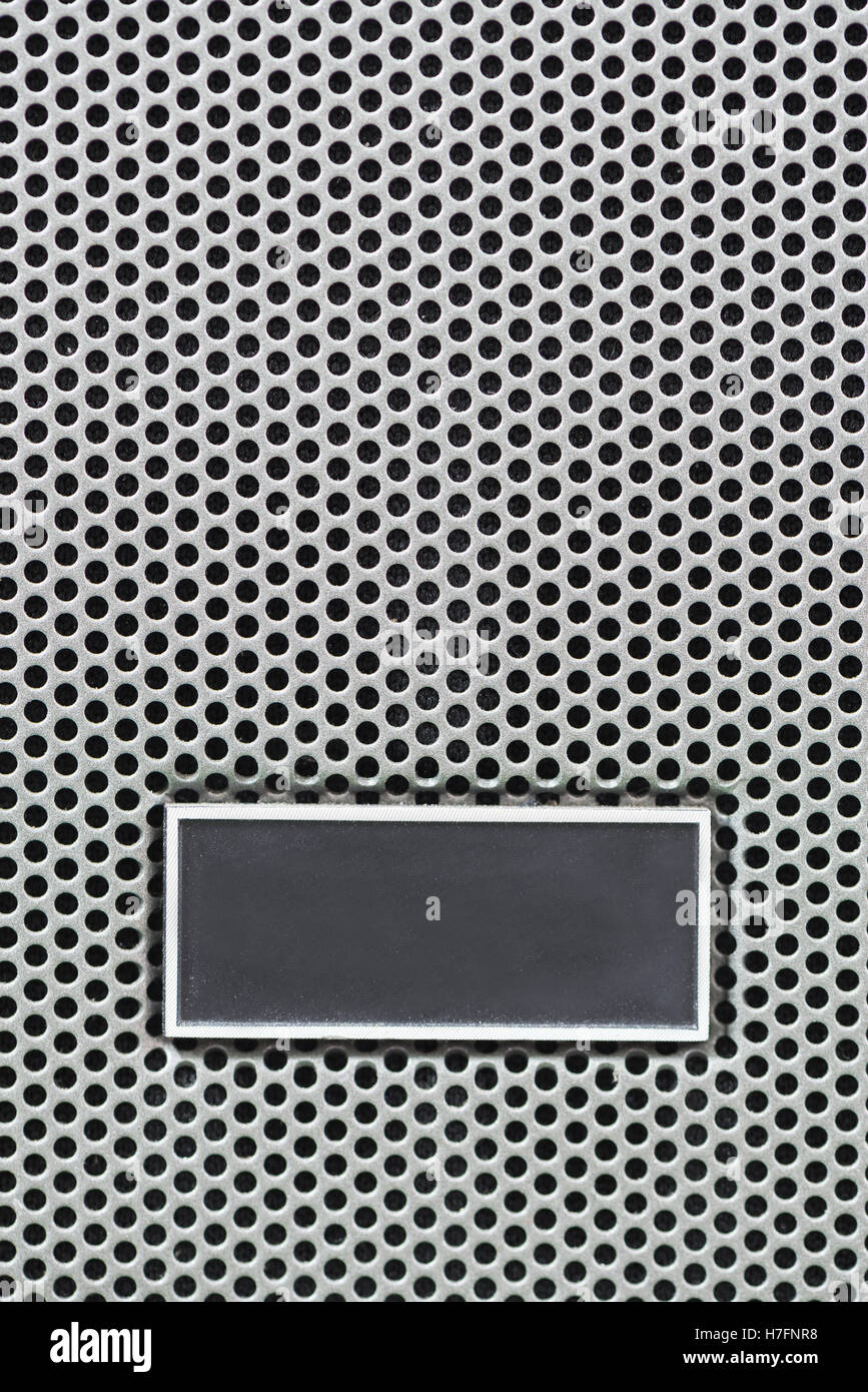 Metal plate label on metal steel grid with repetitive rows of punched ...