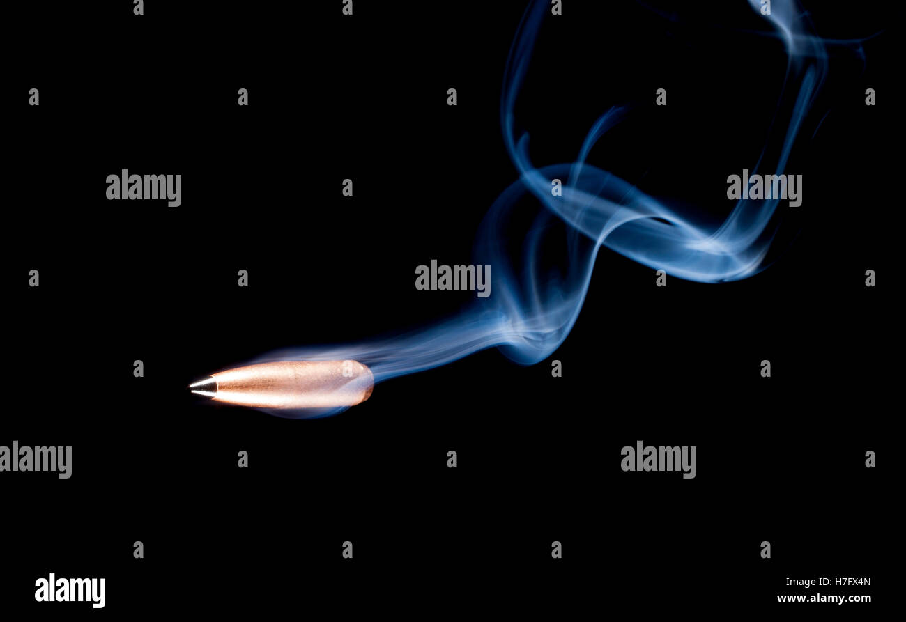 Brassy looking bullet with a polymer tip and smoke behind Stock Photo ...