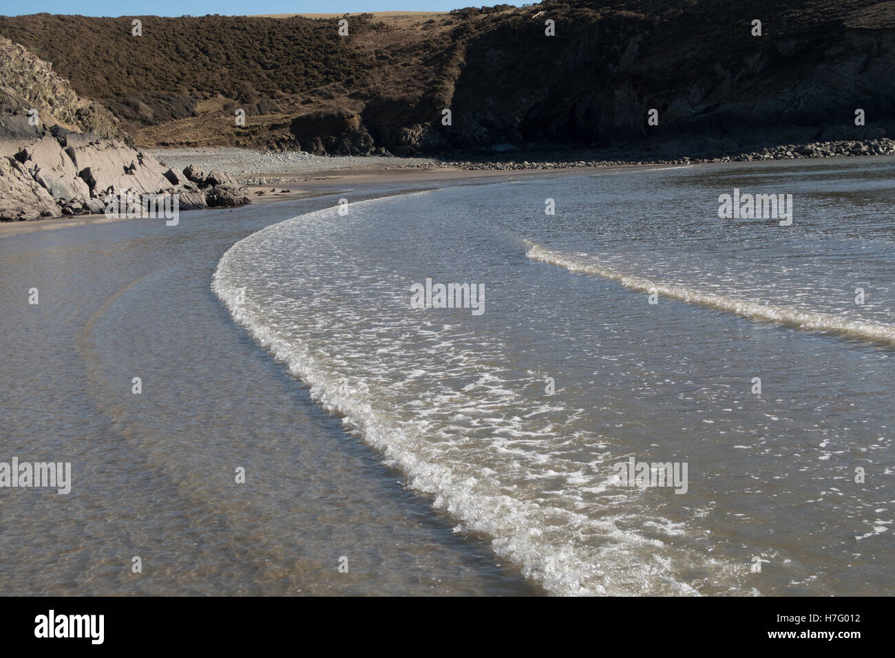 Waves ripple into the sandy beach cove at Solva in United Kingdom Stock ...