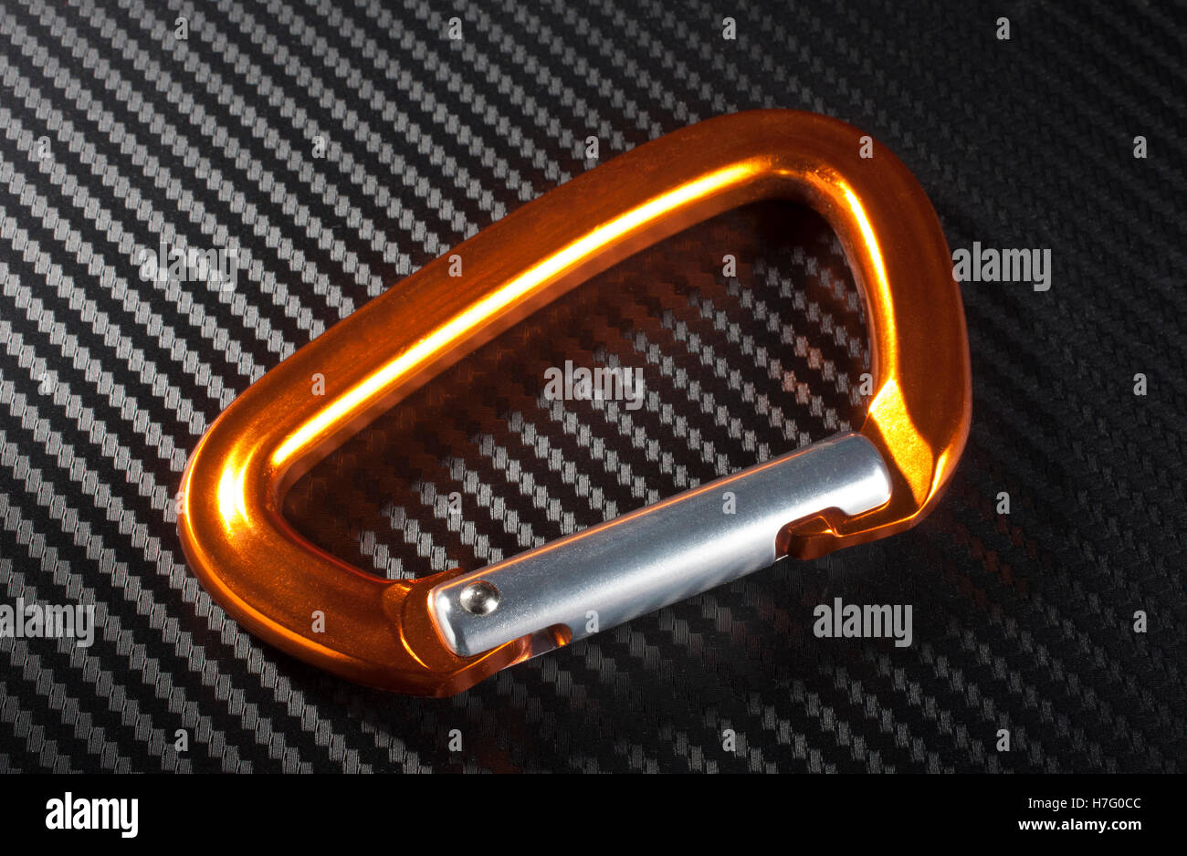 Orange carabiner made for climbing on a graphite background Stock Photo ...