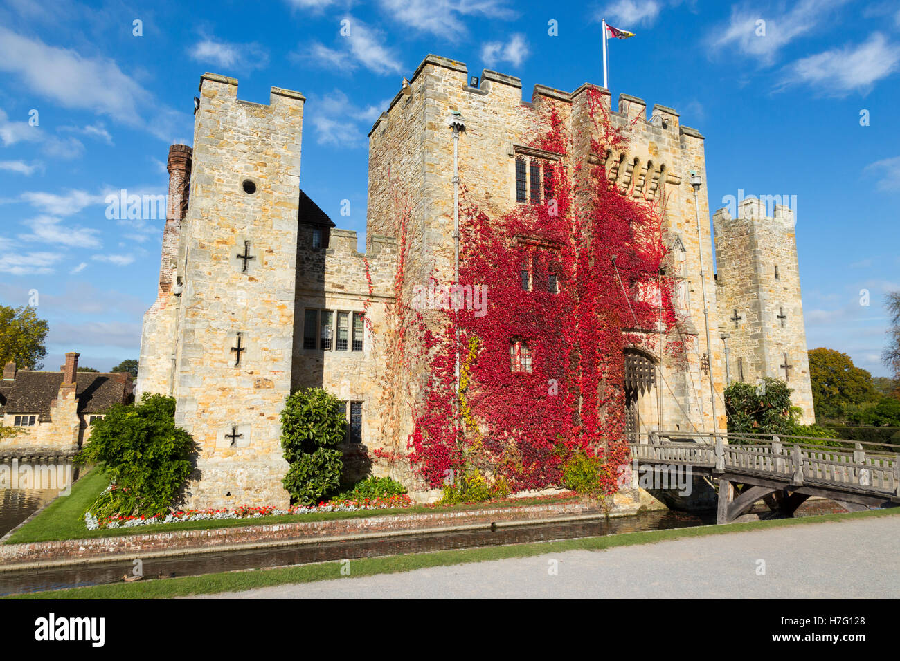 Hever Castle clad with red autumnal virginia creeper: Blue sky / sunny ...