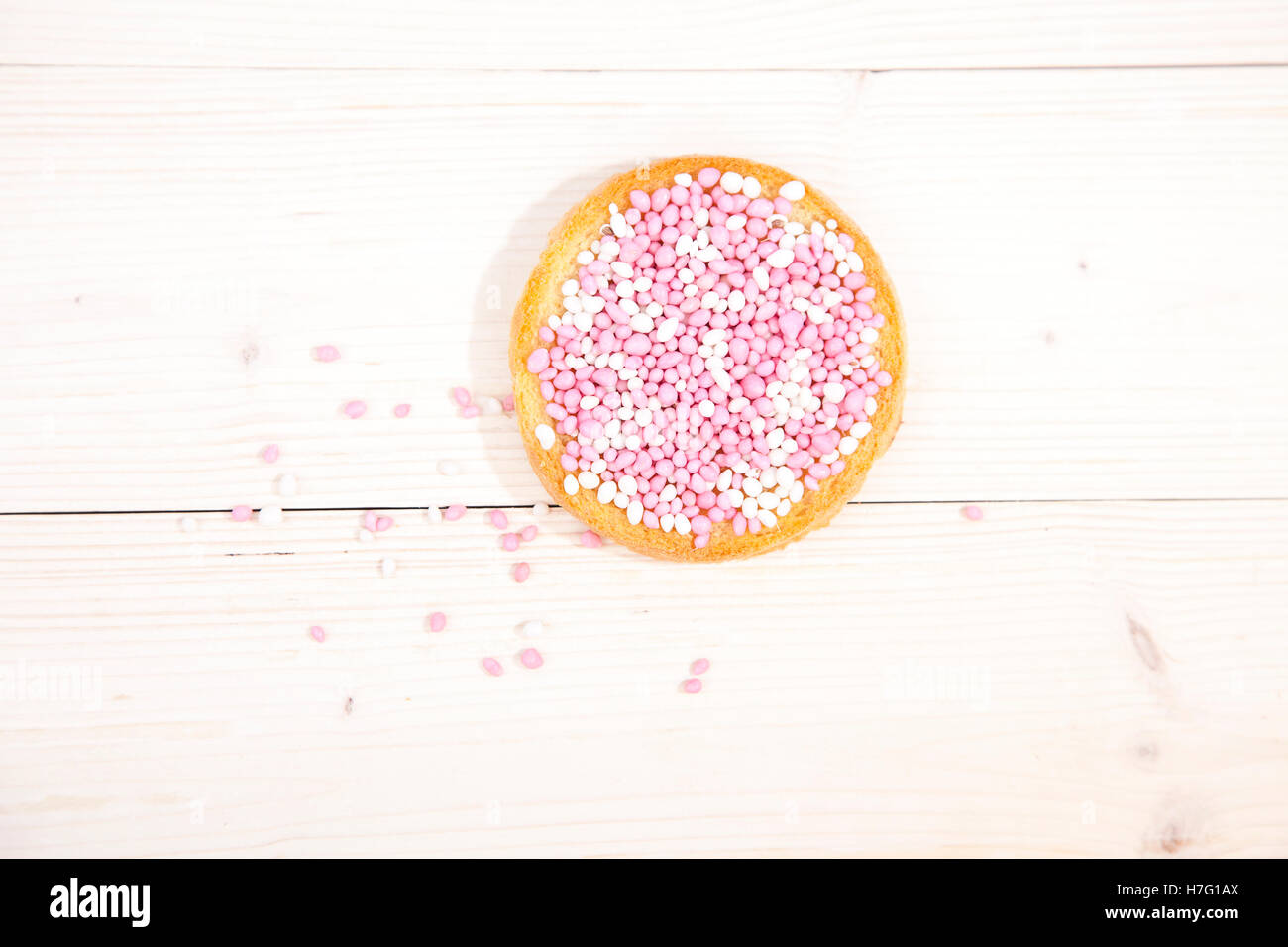 Traditional Dutch birth celebration biscuit with pink muisjes on wooden ...