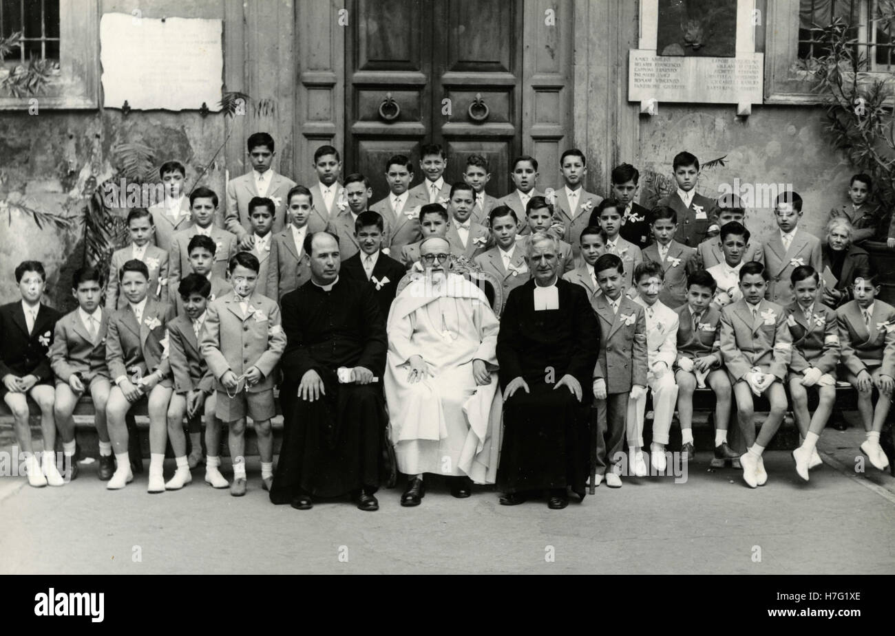 Catholic priests and children dressed for the first communion, Italy ...