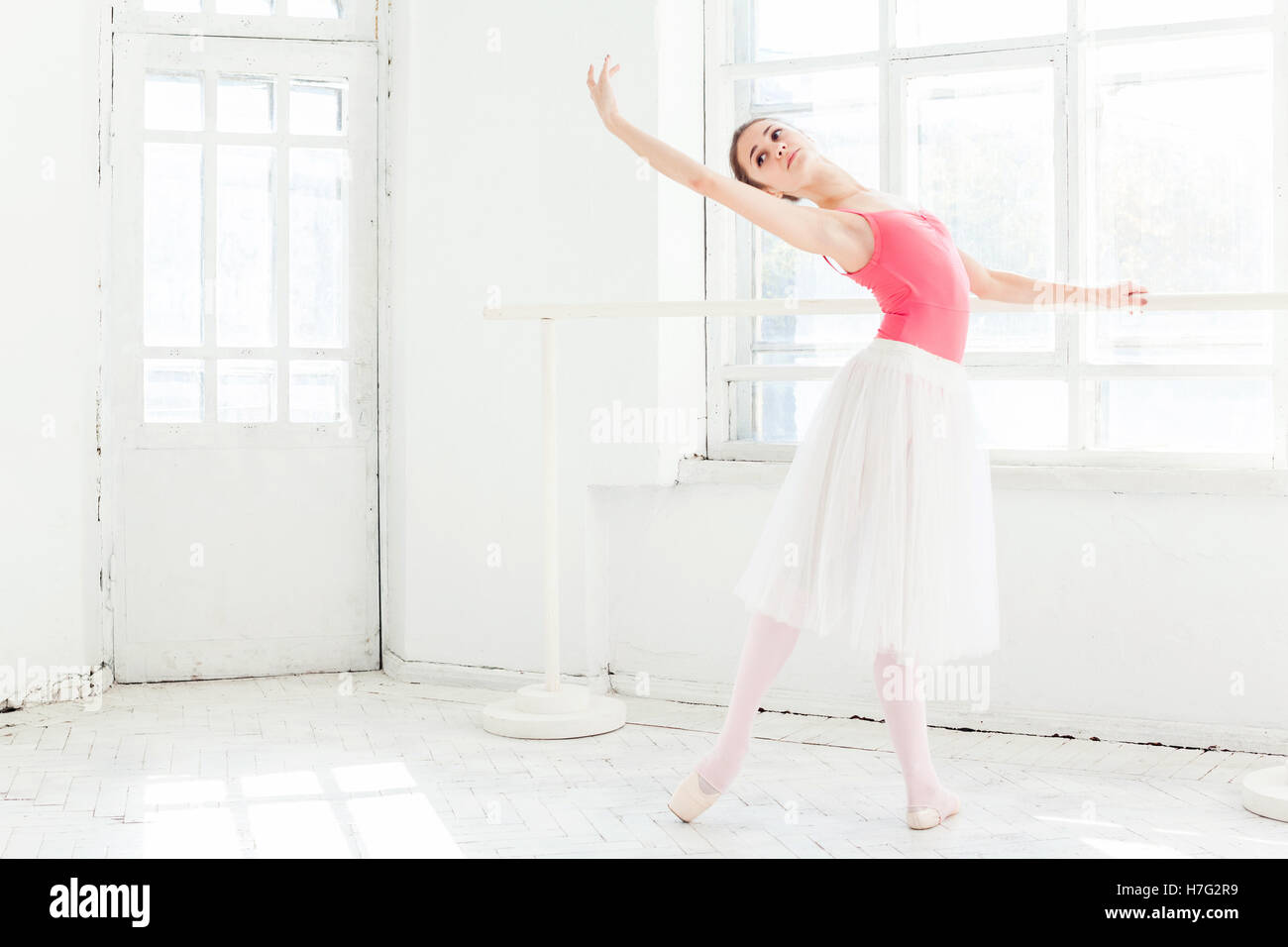 Ballerina posing in pointe shoes at white wooden pavilion Stock Photo ...