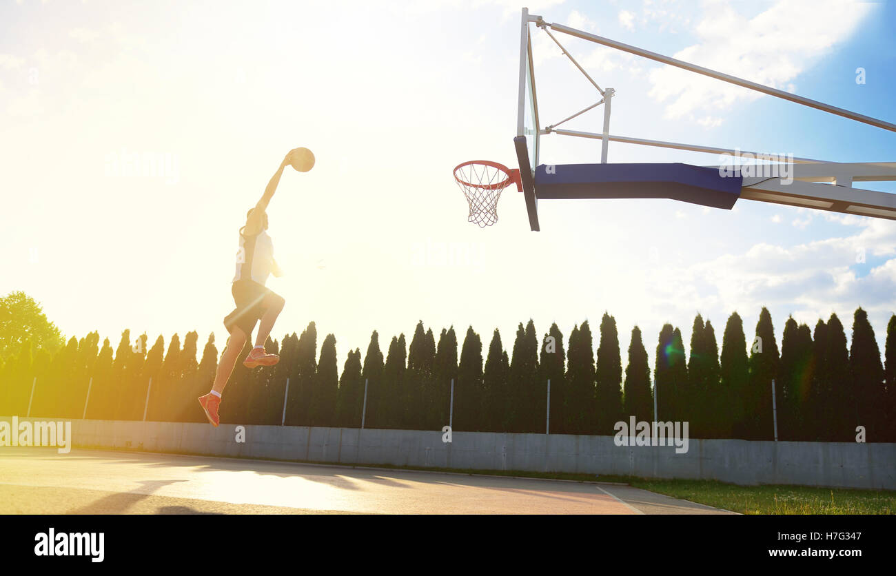 A young basketball player flying towards the rim for a slam dunk Stock ...