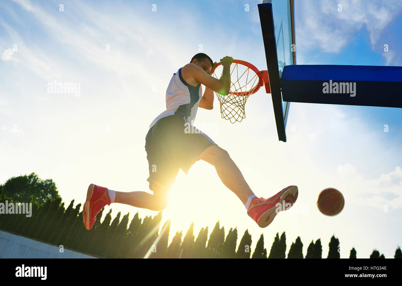 Street basketball player performing power slum dunk Stock Photo - Alamy