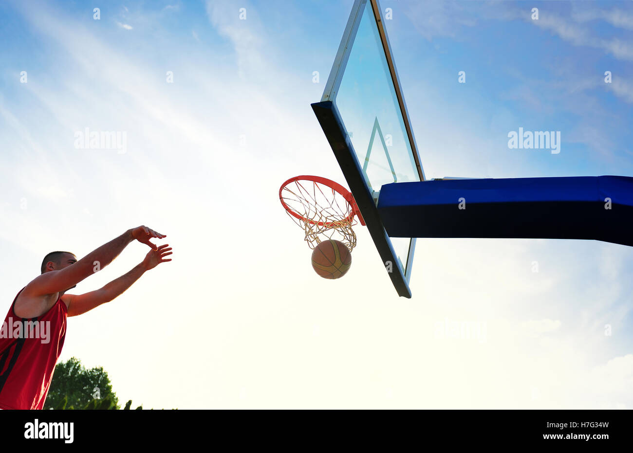 Young basketball player drives to the hoop for a high flying slam dunk ...
