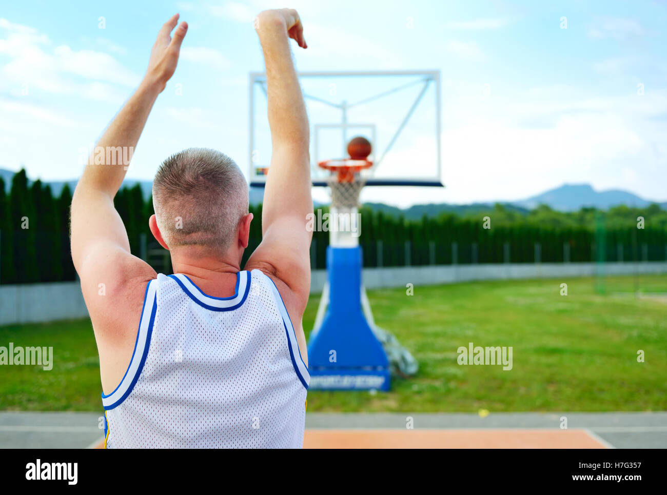 Rear view of a basketball player, shooting at basket outdoor Stock ...