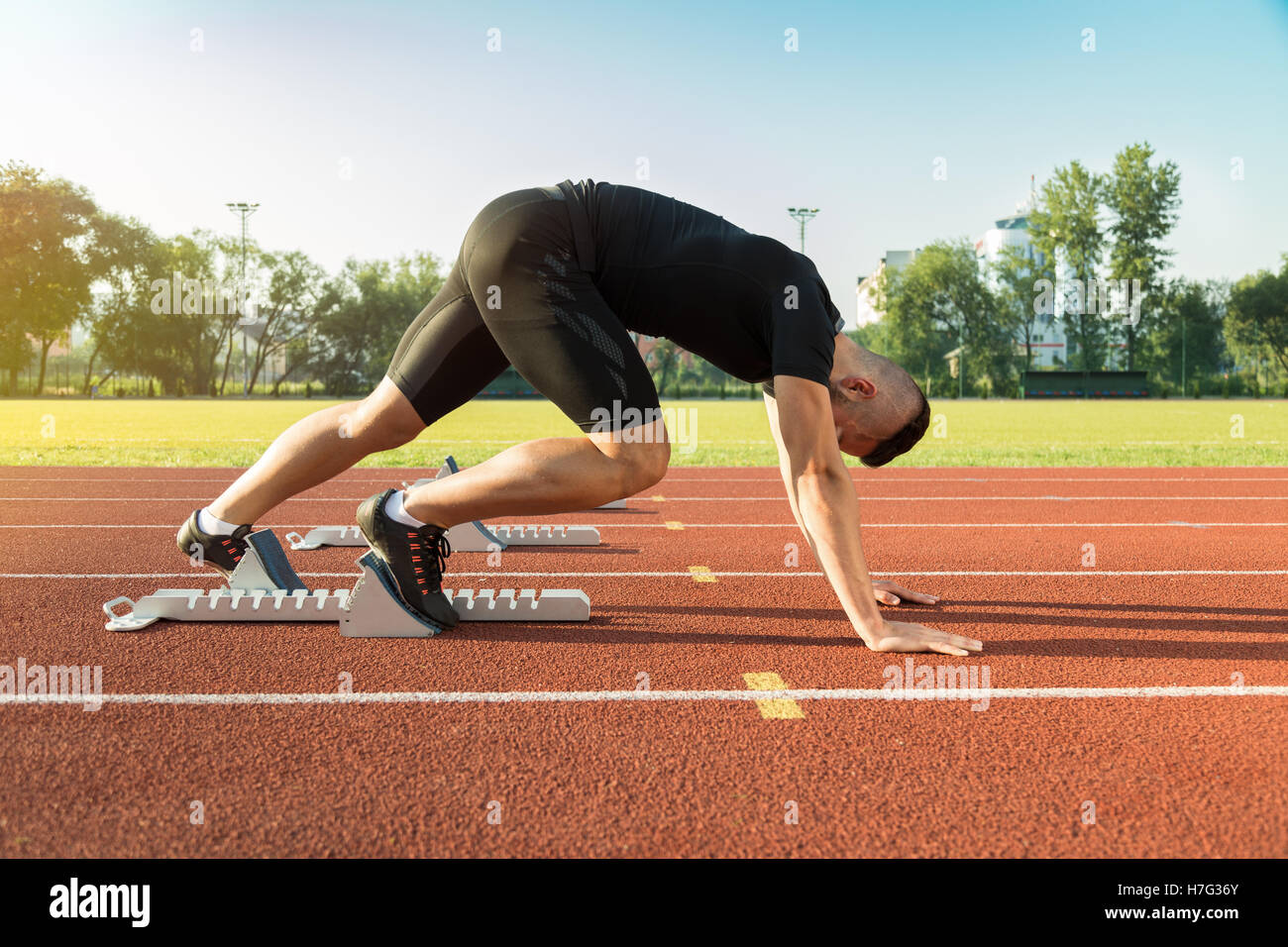 Athletic man starting jogging in sun rays Stock Photo - Alamy