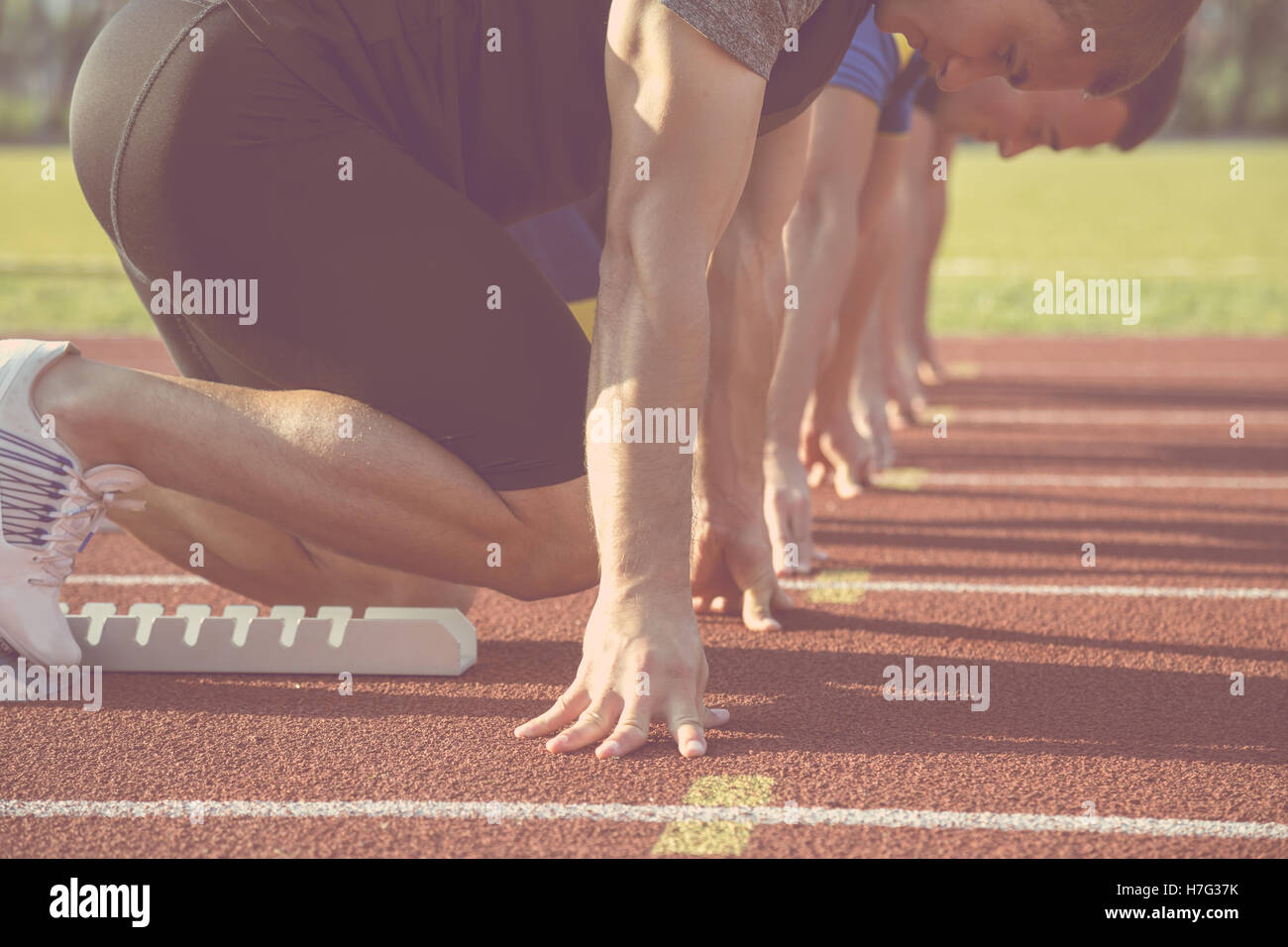 Male athletes at starting line on sunny day Stock Photo - Alamy