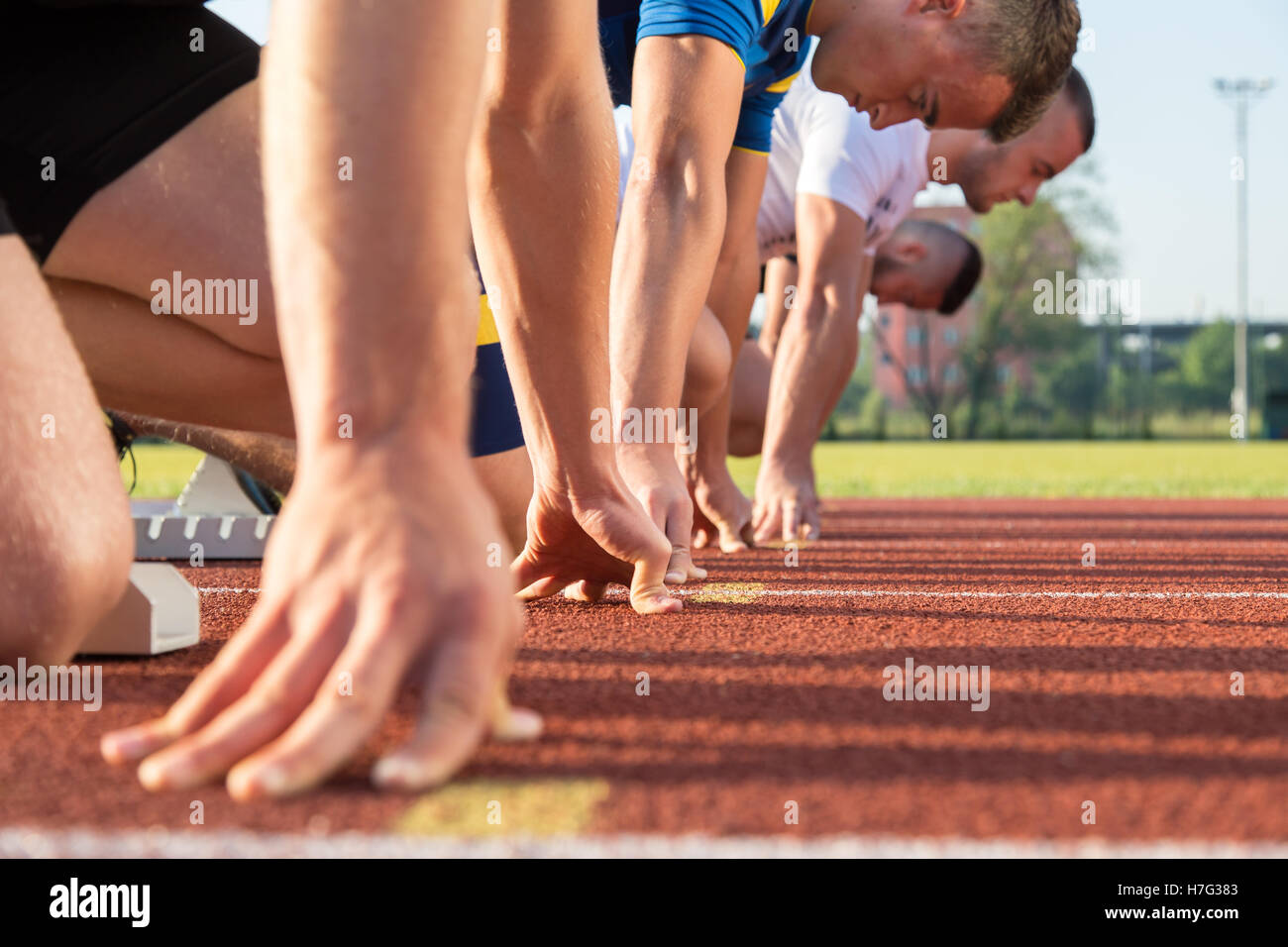 Male athletes at starting line on sunny day Stock Photo - Alamy