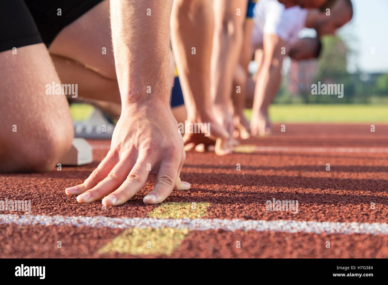 Male athletes at starting line on sunny day Stock Photo - Alamy