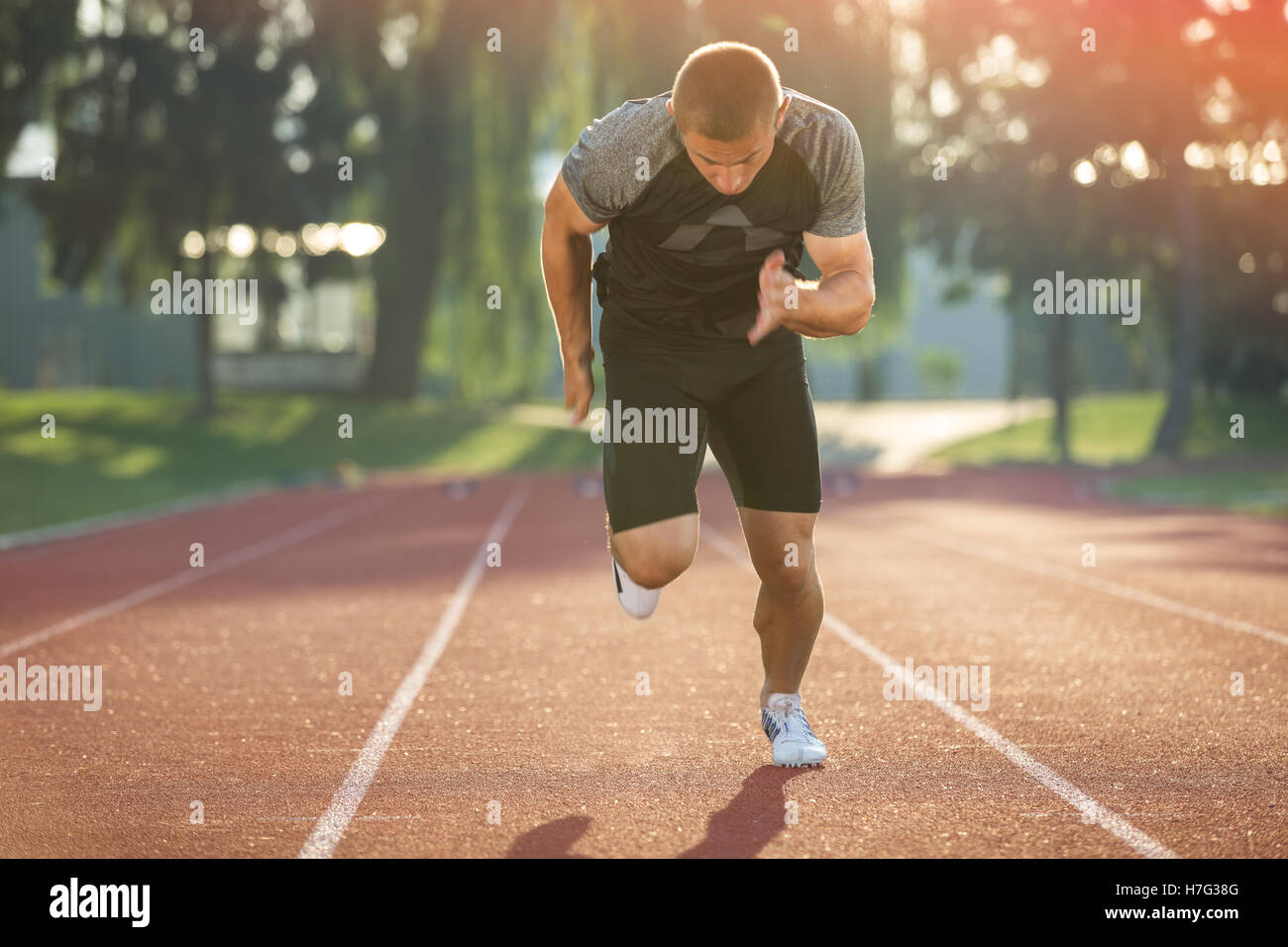 Track runner in starting position on sunny morning Stock Photo - Alamy