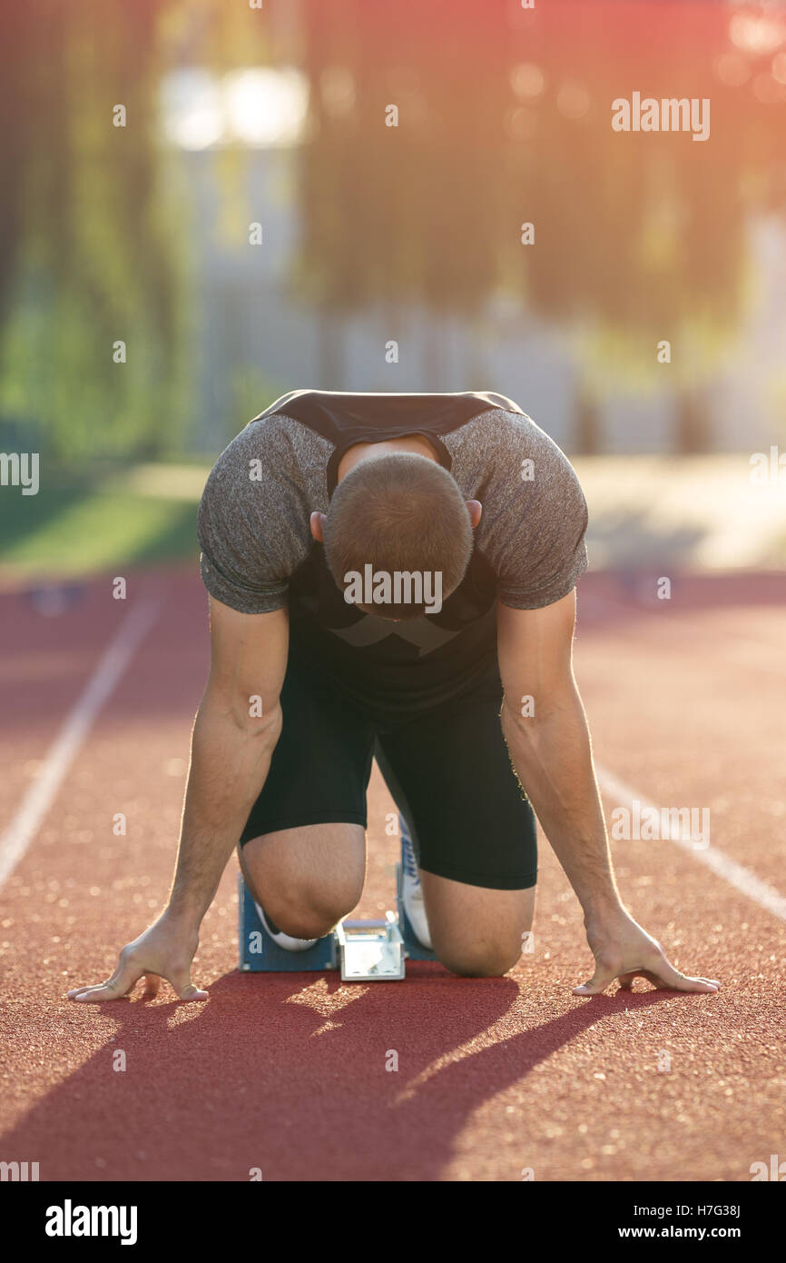 Track runner in starting position on sunny morning Stock Photo - Alamy