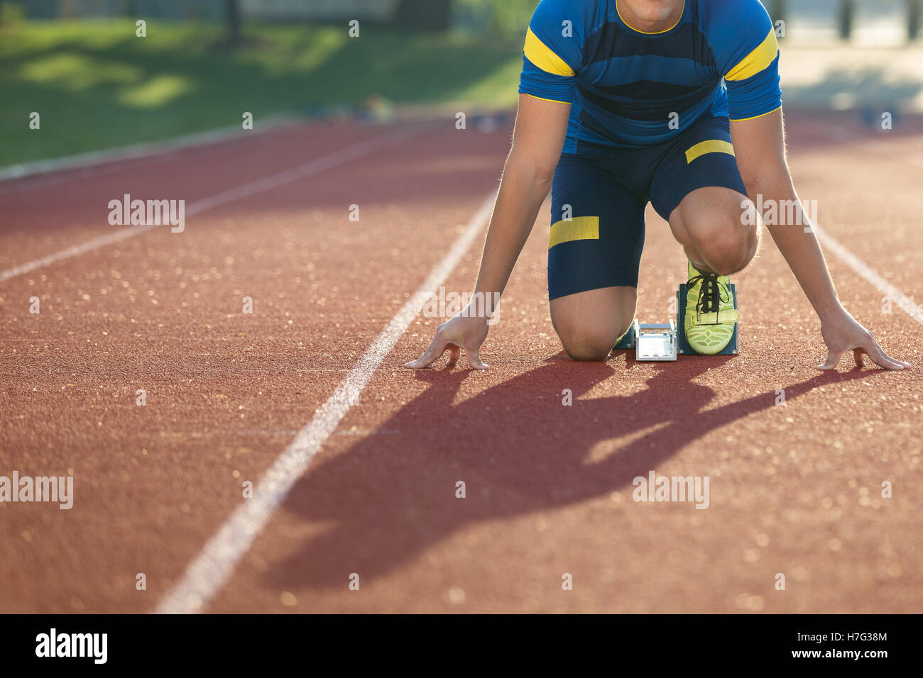 Track runner in starting position on sunny morning Stock Photo - Alamy