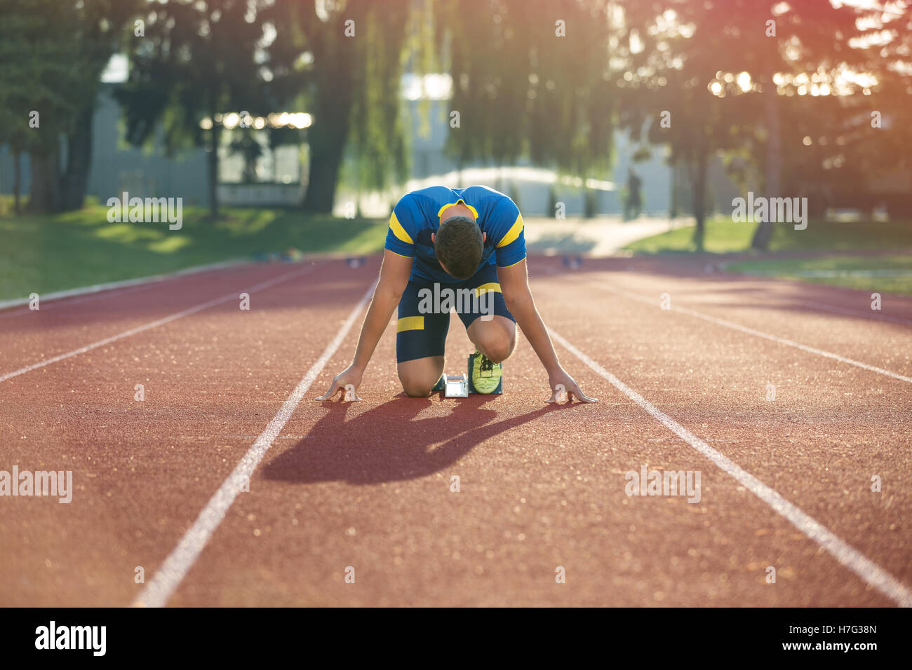 Track runner in starting position on sunny morning Stock Photo - Alamy
