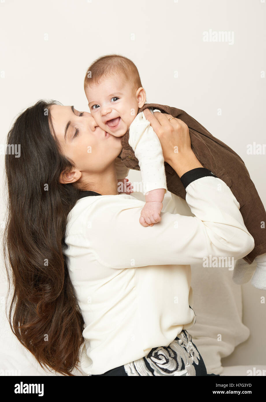Mother raising baby and play, happy family portrait on white background ...