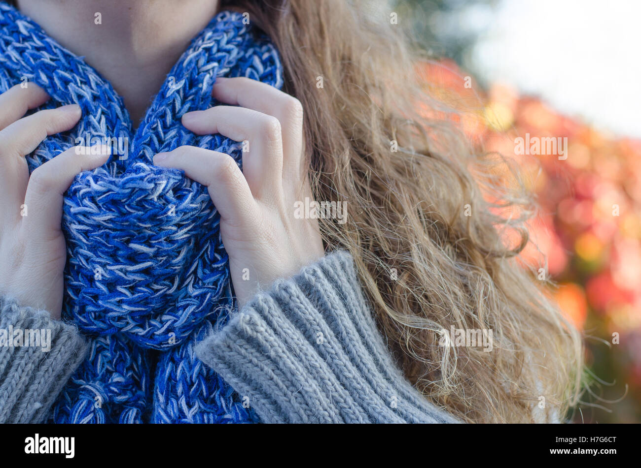 Woman putting blue scarf Stock Photo - Alamy