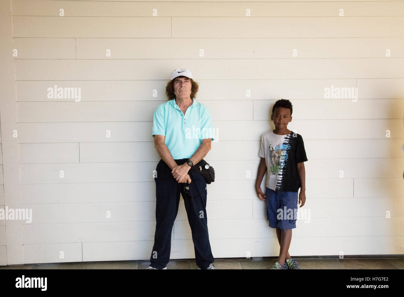 man with boy standing against wall Stock Photo - Alamy