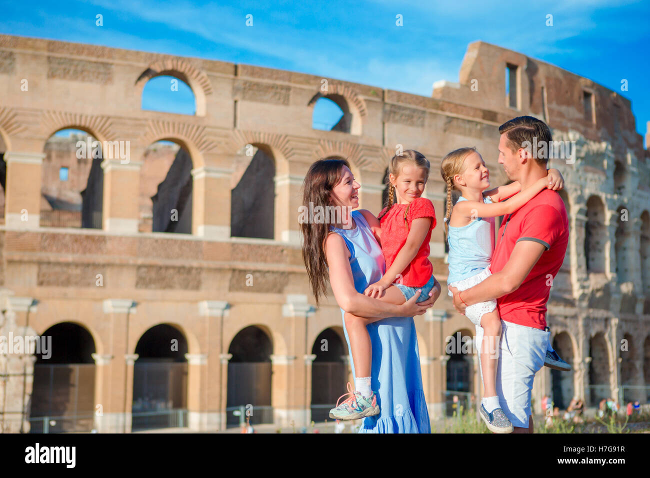 Happy family in Europe. Parents and kids in Rome over Coliseum ...