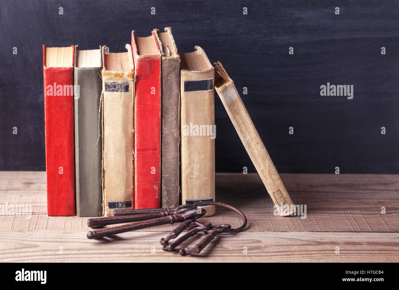Stack of old vintage books and a bunch of old big iron keys lie on a ...