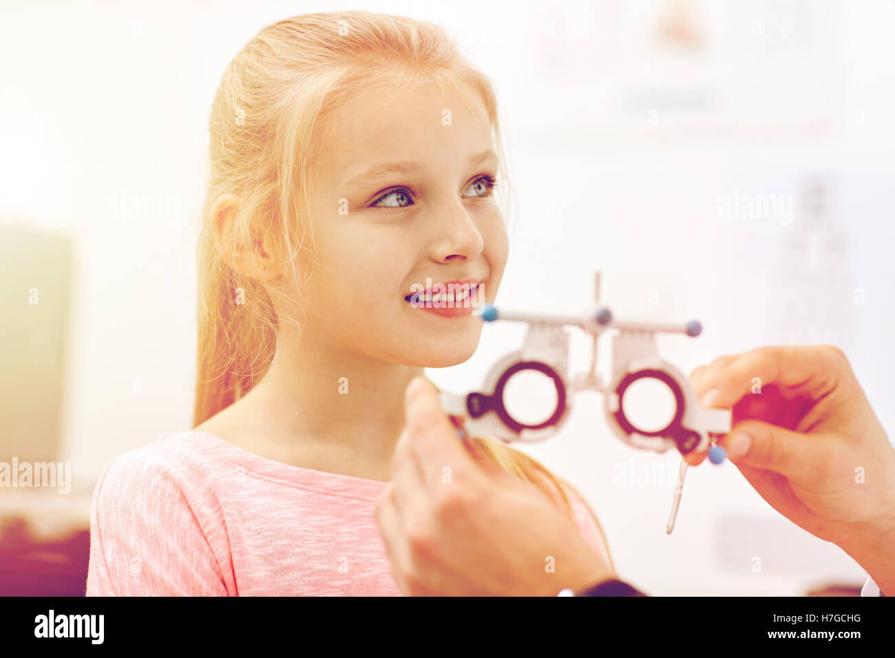 optician with trial frame and girl at clinic Stock Photo - Alamy