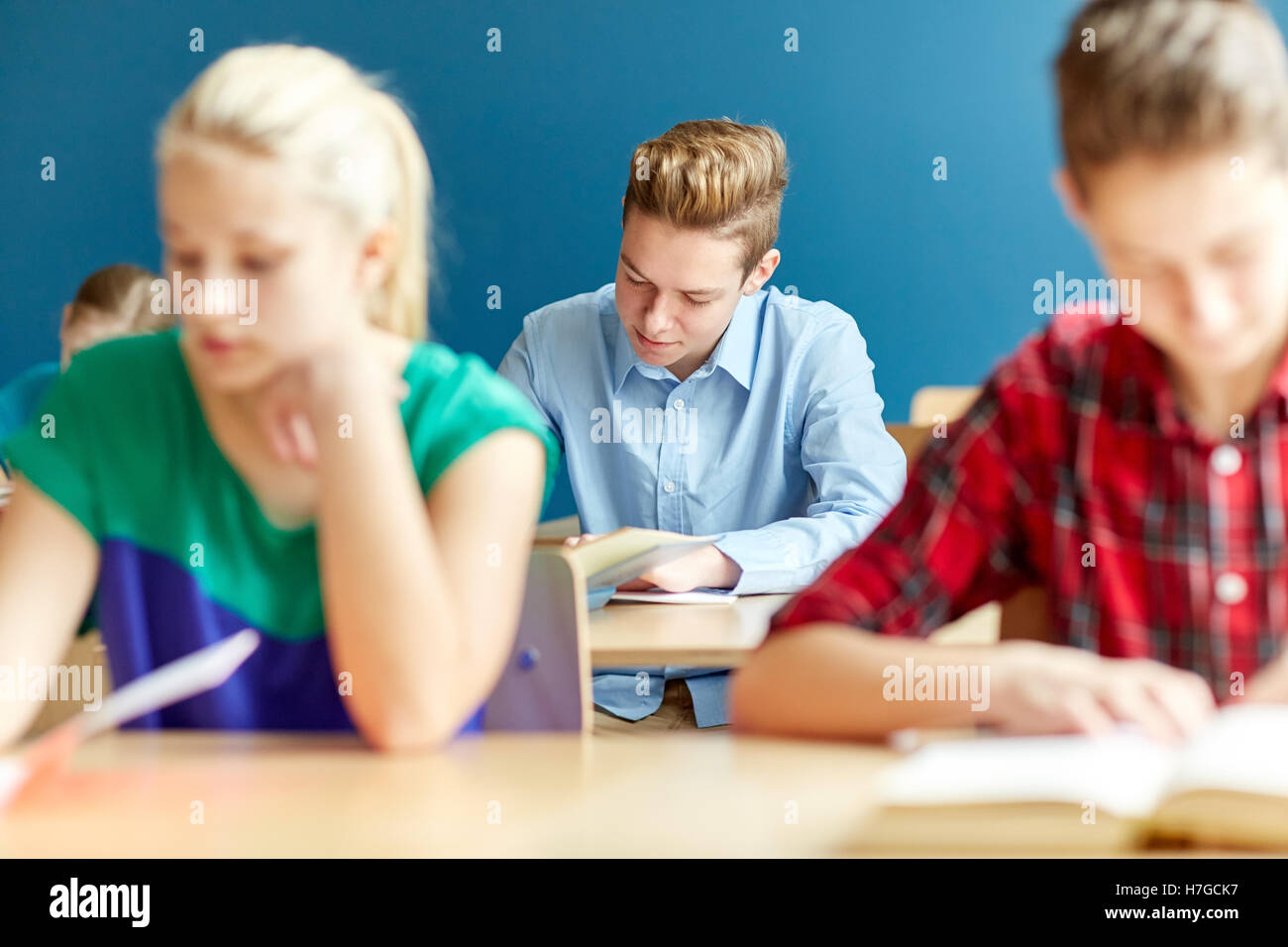 group of students with books writing school test Stock Photo - Alamy