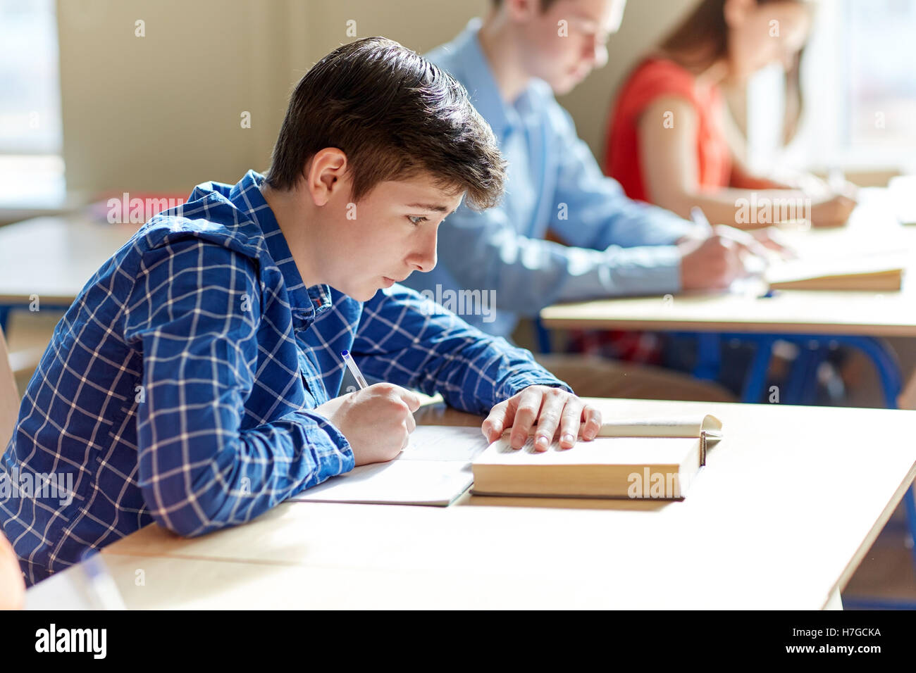 group of students with books writing school test Stock Photo - Alamy