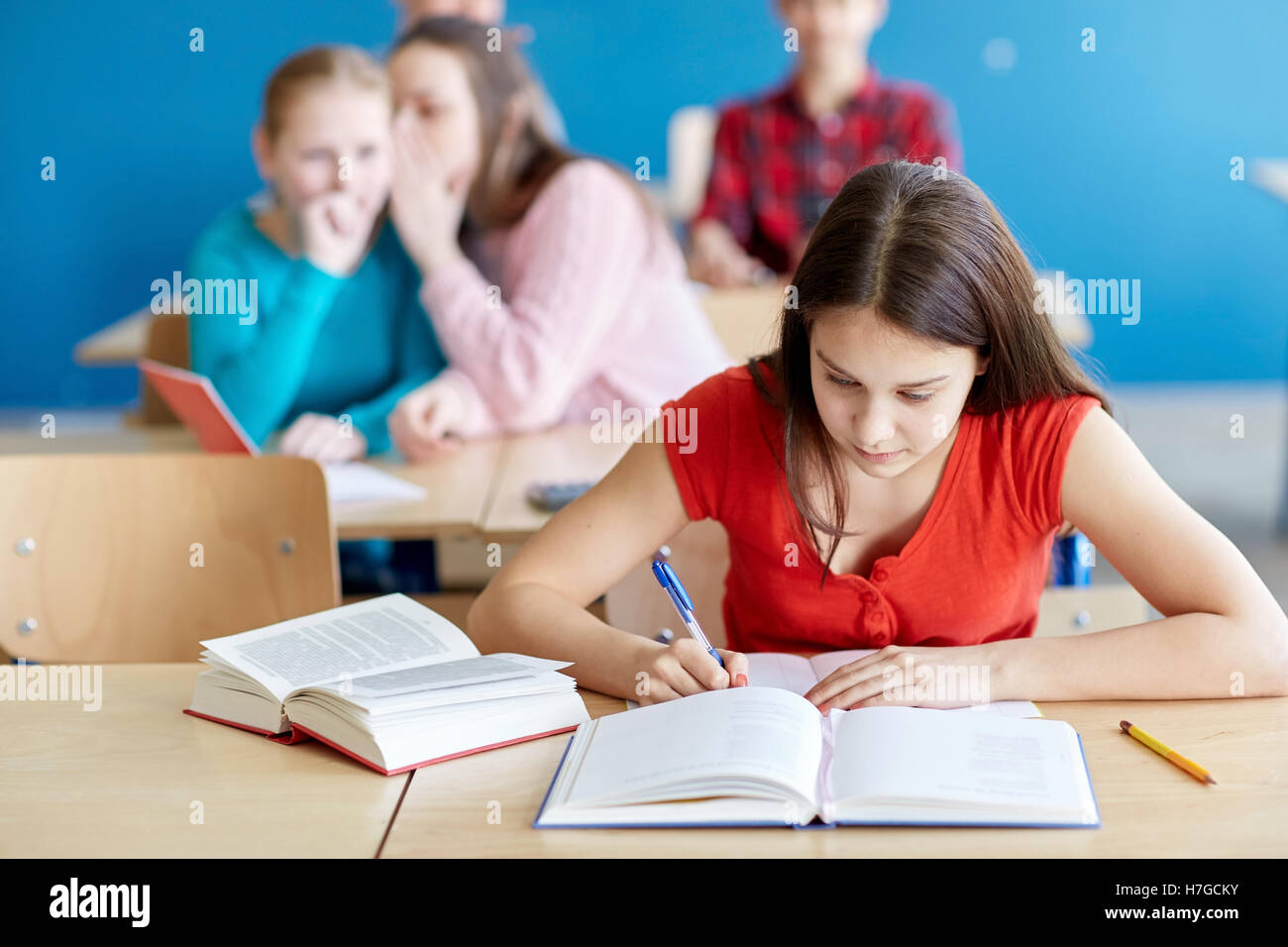 students gossiping behind classmate back at school Stock Photo - Alamy