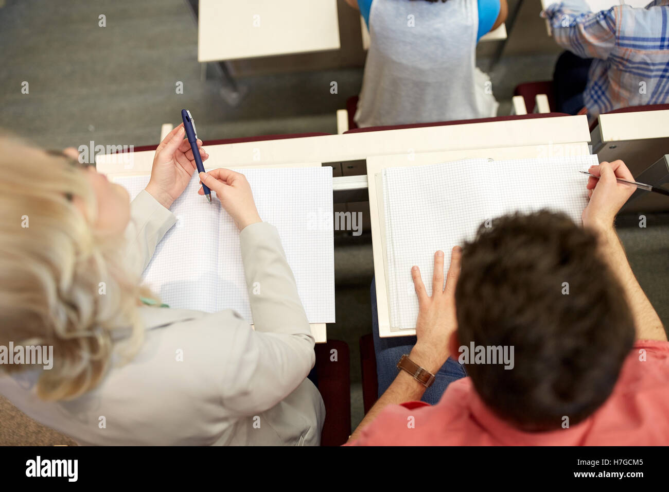 students with notebooks at exam or lecture Stock Photo - Alamy