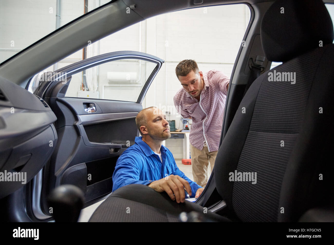 Young man in the middle of a car repair hi-res stock photography and ...