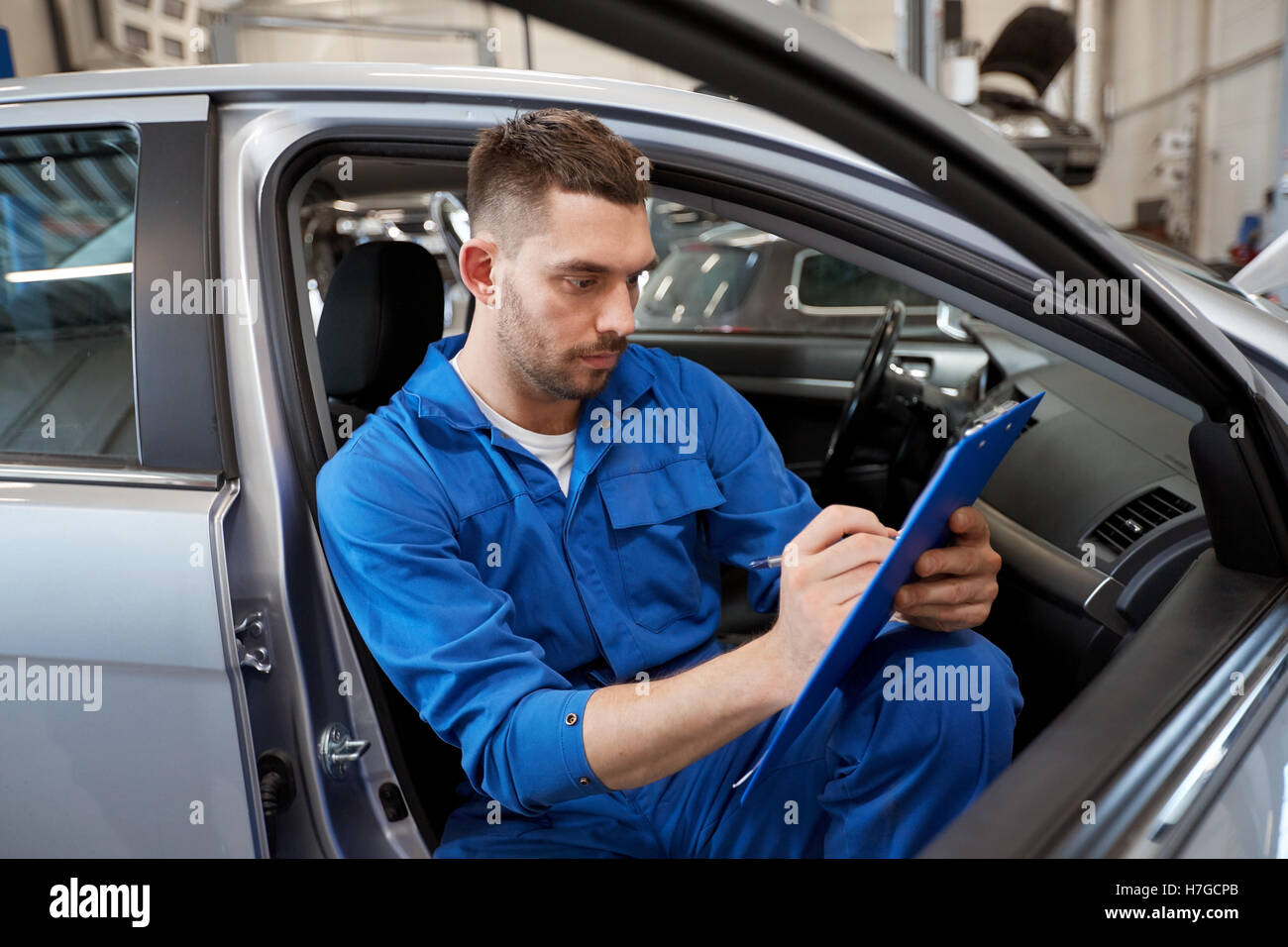auto mechanic man with clipboard at car workshop Stock Photo - Alamy